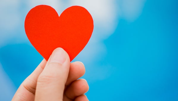 closeup-hand-holding-red-paper-heart-shape-on-blue-background-love-and ...